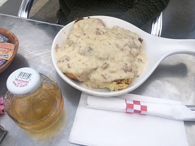 Behold the star attraction—biscuits drowning in peppery gravy that's studded with sausage bits, a comfort food masterpiece worth setting alarms for.