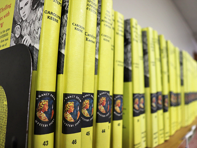 Nancy Drew mysteries lined up like soldiers in their iconic yellow jackets—literary nostalgia by the yard for anyone who grew up solving cases alongside America's favorite teen detective.