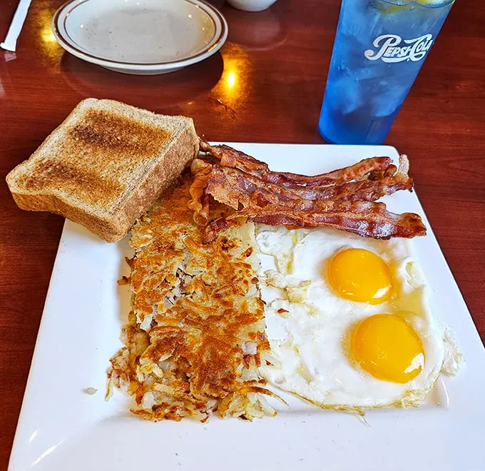 Breakfast perfection doesn't need fancy names or ingredients. Two sunny eggs, crispy hash browns, and bacon that would make even a cardiologist pause with desire.