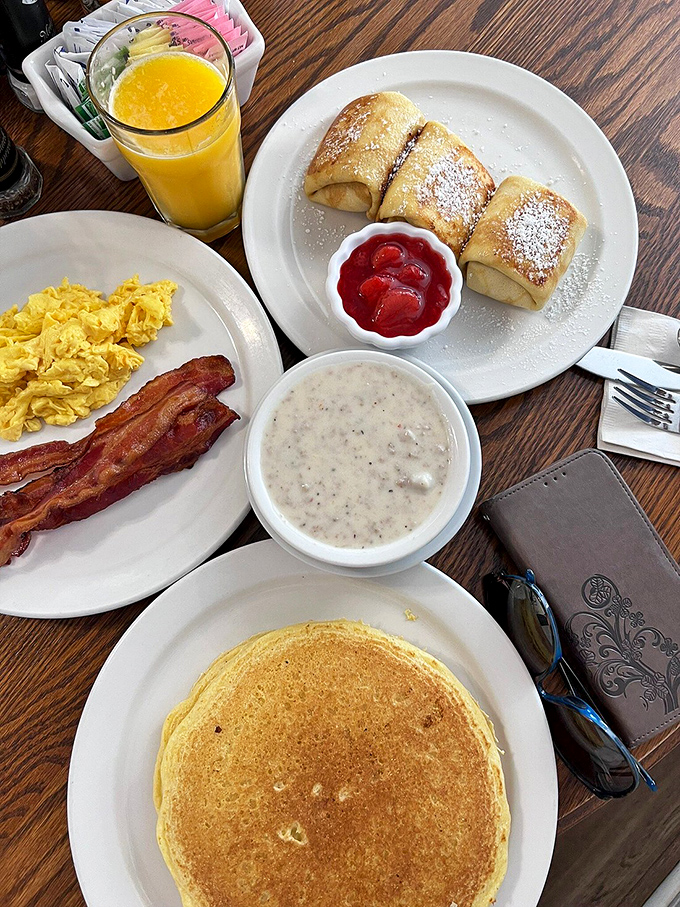 Breakfast perfection on a plate: golden pancakes, scrambled eggs that look like clouds, and bacon that's achieved that mythical balance between crisp and chewy.