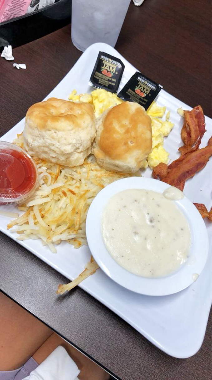 Fluffy biscuits, golden hash browns, perfectly scrambled eggs, and crispy bacon—this breakfast plate isn't just a meal, it's a Tennessee morning tradition on porcelain.