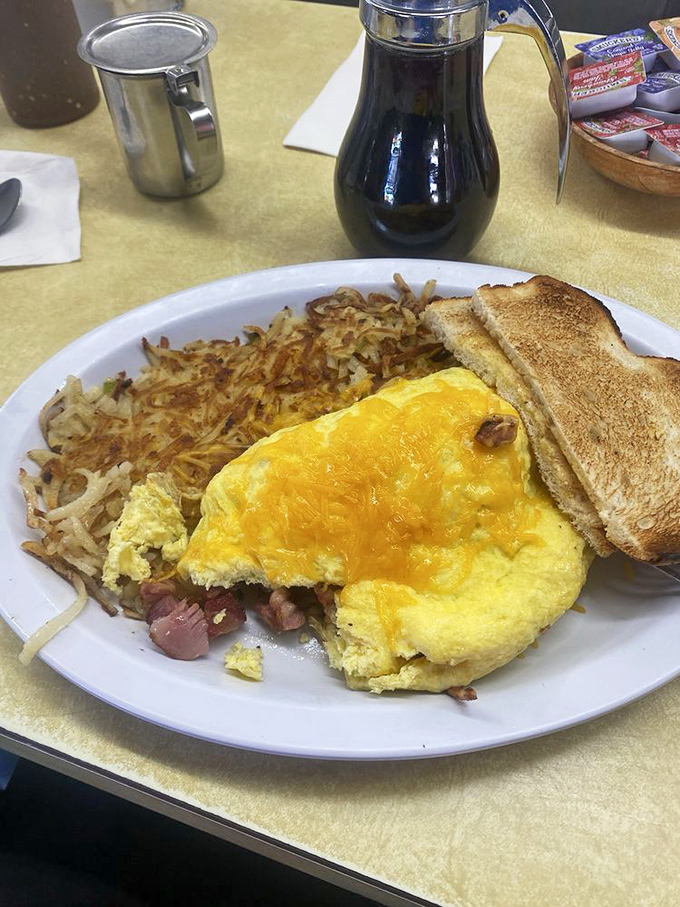 Behold the holy trinity of breakfast perfection: a golden omelet, crispy hash browns, and toast that's achieved that magical balance between crunch and give. Coffee non-negotiable.