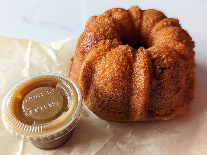 This golden bundt cake isn't just dessert—it's architecture with purpose. The caramel sauce alongside is basically liquid gold that would make King Midas jealous.