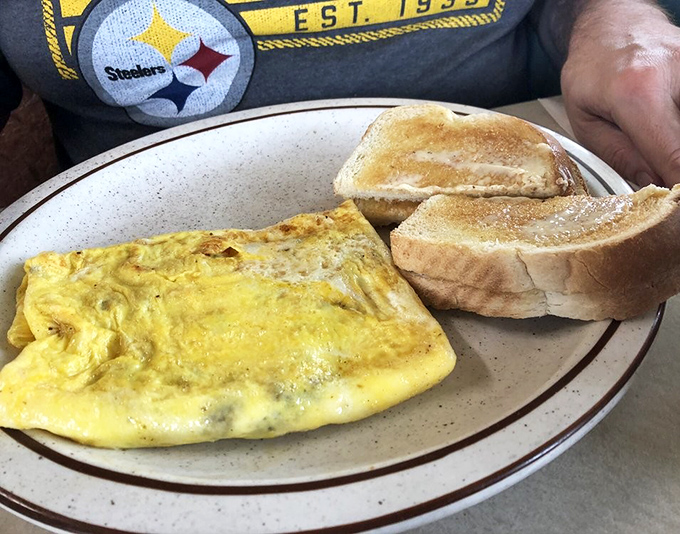 
Behold the cheese omelet—sunshine yellow, perfectly folded, and paired with toast that's achieved that magical butter-to-crunch ratio only diners seem to master.