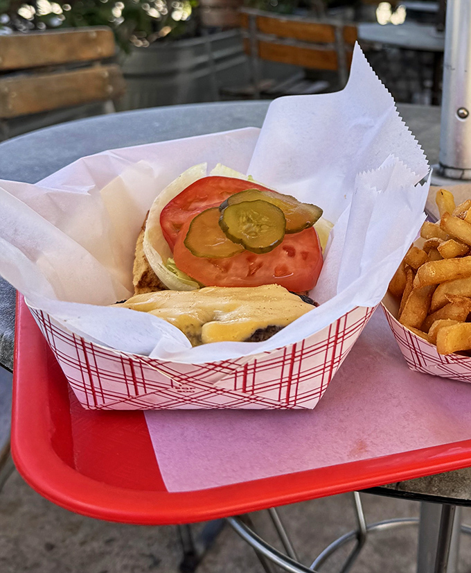 This isn't just a burger—it's an architectural masterpiece. Layers of pickle, tomato, and cheese create the perfect savory skyscraper of satisfaction.