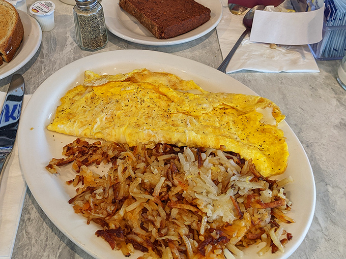 This isn't just an omelet—it's breakfast architecture. Golden eggs draped over crispy hash browns create the perfect morning masterpiece.