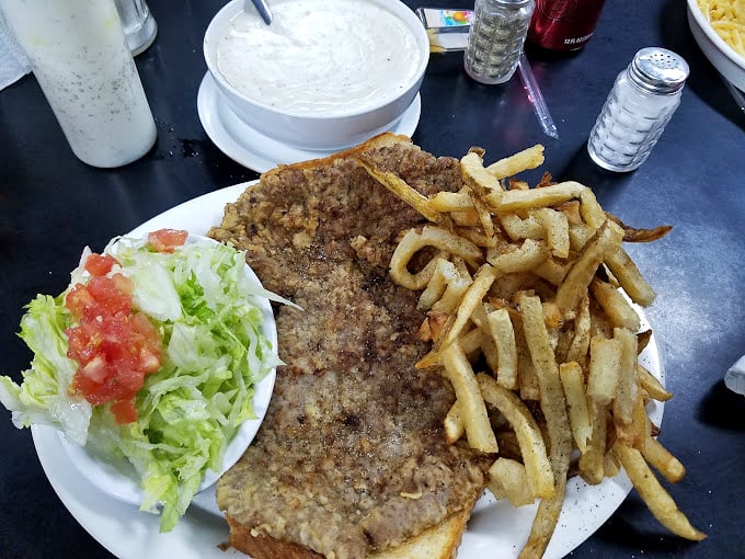 Behold the star attraction: a chicken fried steak that hangs off the plate like Texas itself – big, bold, and unapologetically delicious.