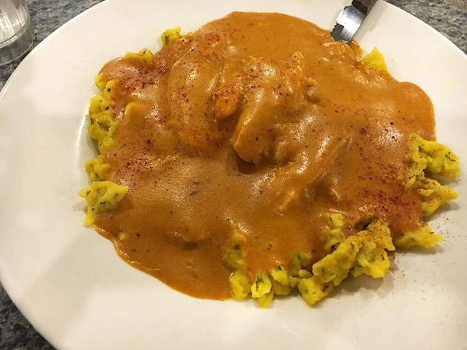 Behold the legendary chicken paprikash! Tender chicken swimming in paprika-infused sauce atop homemade spaetzle—Hungarian grandmothers everywhere would approve.