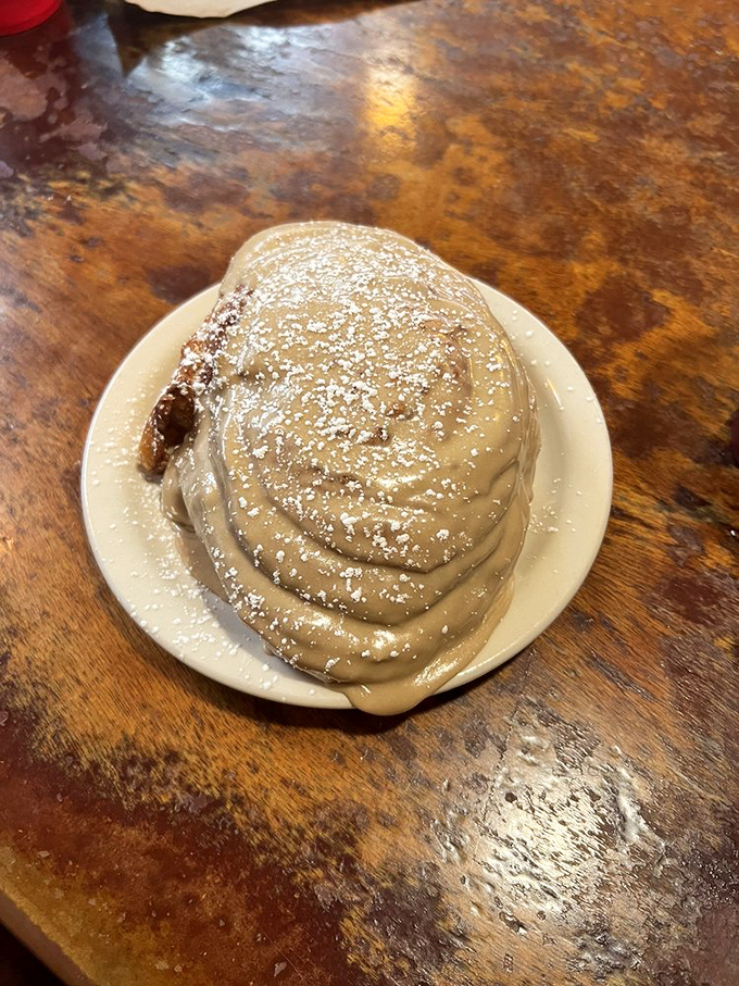 This isn't just a cinnamon roll; it's an edible cloud of happiness dusted with powdered sugar that makes Monday mornings bearable again.