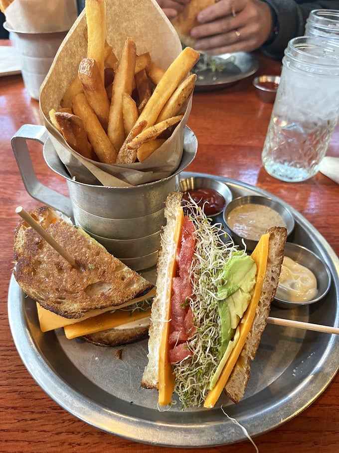 This isn't just a sandwich—it's an architectural marvel of flavor, where crispy fries stand at attention beside layers of fresh vegetables.