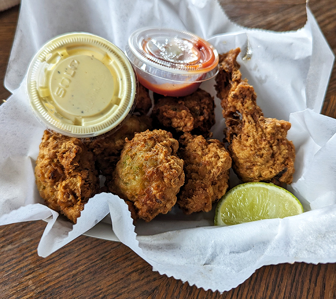 Golden-brown conch fritters that crunch like a perfect vinyl record drop, with tender morsels inside that taste like the ocean's sweetest secret.
