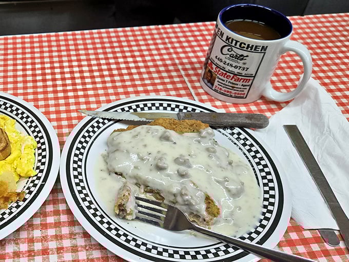 Country fried steak swimming in creamy gravy – where comfort food meets art form. The fork marks tell you someone couldn't wait!