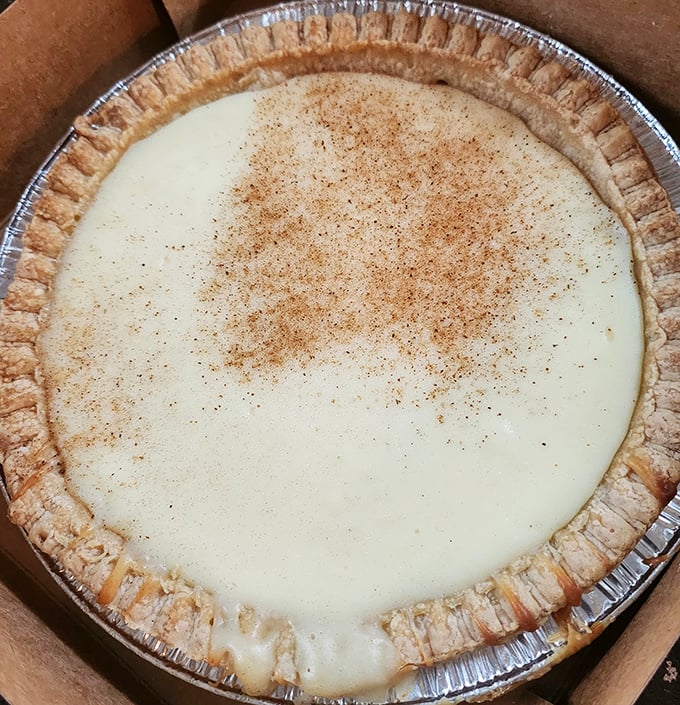 This custard pie with its perfectly crimped edges and dusting of cinnamon isn't just dessert—it's edible artwork that whispers "resistance is futile."