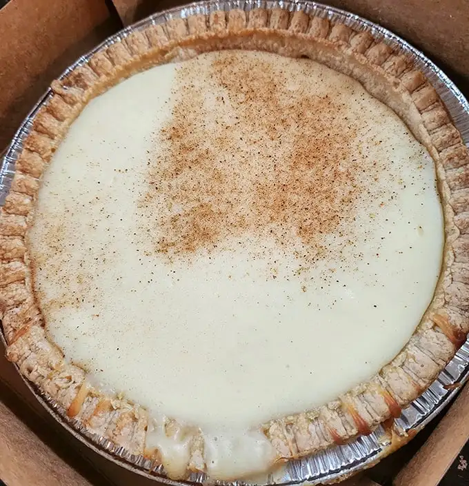 This custard pie with its perfectly crimped edges and dusting of cinnamon isn't just dessert—it's edible artwork that whispers "resistance is futile."