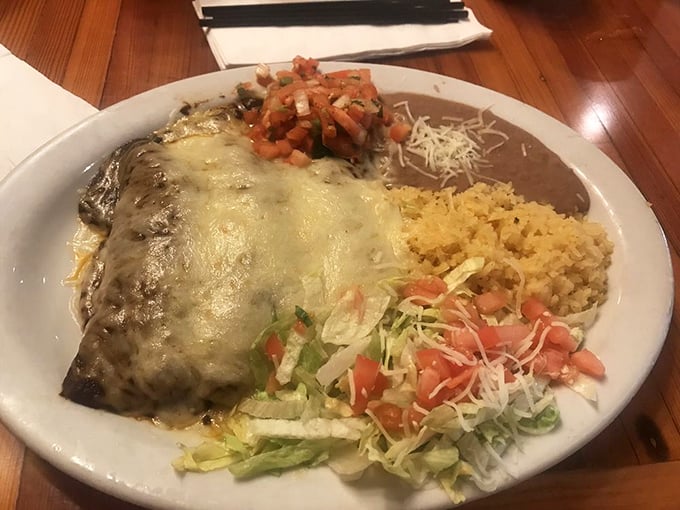 This isn't just an enchilada—it's a cheese-blanketed masterpiece flanked by perfect rice and beans. The kind of plate that makes you consider moving closer to the restaurant. 