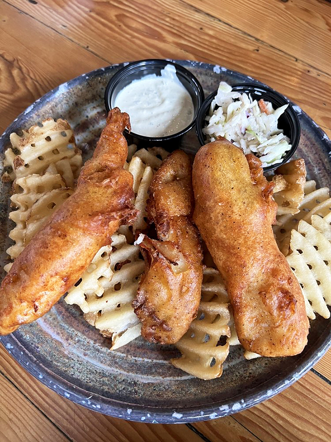Golden-battered fish perched atop waffle fries—this isn't just fish and chips, it's edible sunshine. The crispy exterior gives way to flaky perfection that would make Neptune himself jealous.