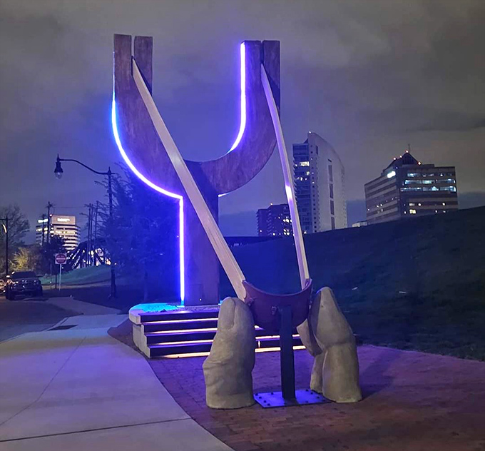 As night falls, The Slingshot transforms with illumination, its glowing blue outline creating a neon dreamscape against the Columbus skyline.