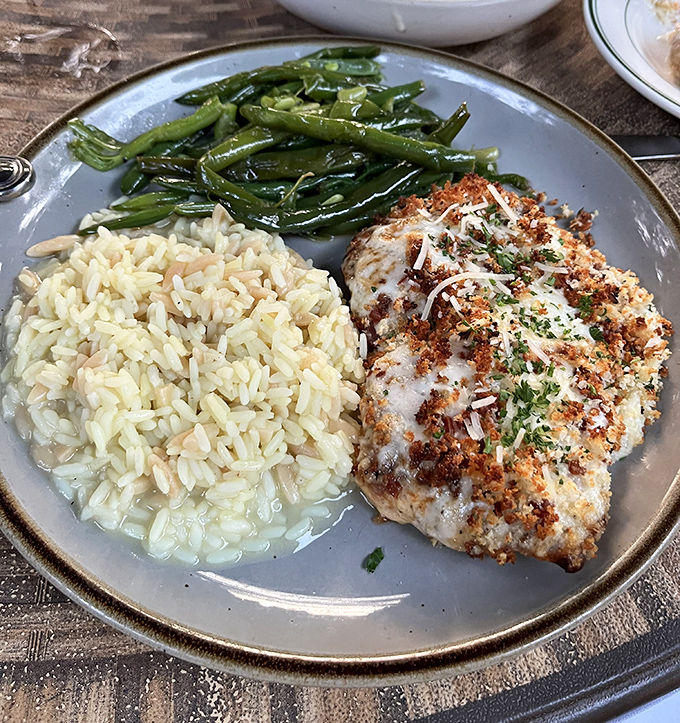 Behold the famous grouper that launches road trips! Perfectly seared, resting on rice pilaf with green beans—a plate that proves Missouri knows seafood.