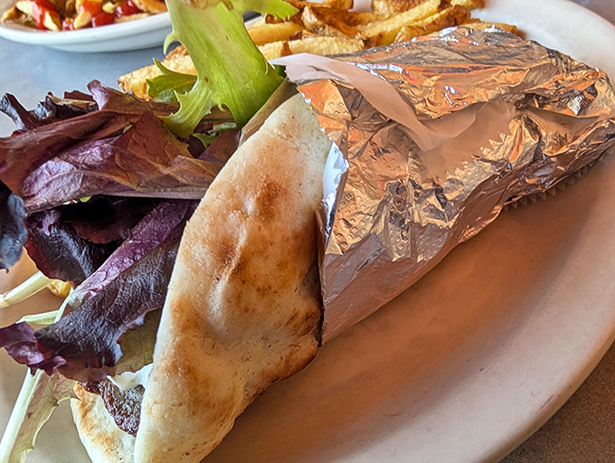 This isn't just a gyro—it's a Mediterranean vacation wrapped in foil, with crisp lettuce providing the perfect contrast to seasoned meat.