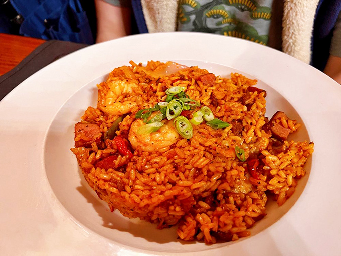 Charleston red rice that doesn't just sit on the plate—it performs, with plump shrimp and green onions playing supporting roles in this Southern classic.