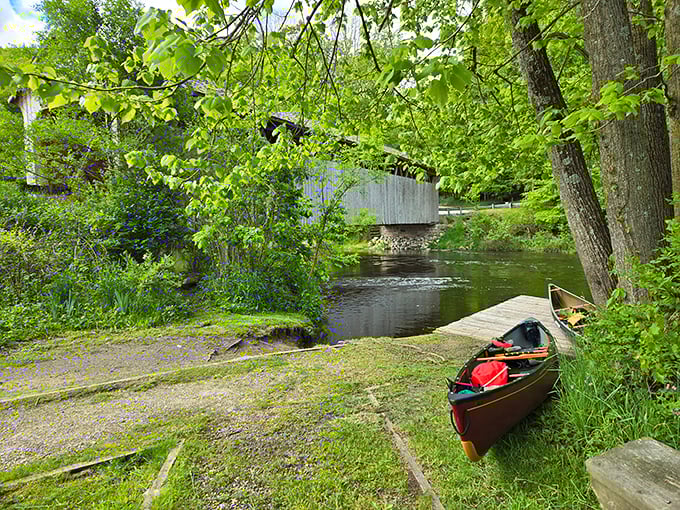 Adventure awaits just beyond the bridge. A canoe ready for exploration reminds us that sometimes the best views come from the water looking back.