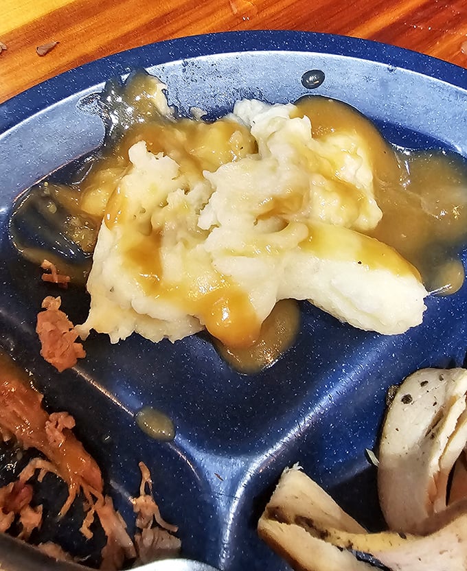 Behold the mashed potatoes that launched a thousand road trips, swimming in gravy that would make your grandmother both jealous and proud.