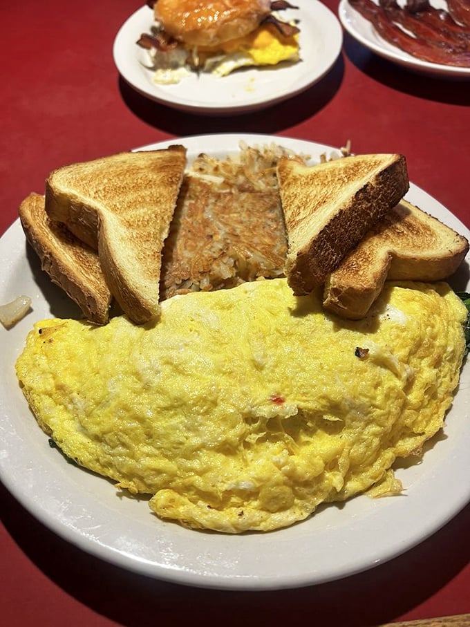 Behold the perfect omelet—fluffy as a cloud, golden as sunrise, with home fries that could make a potato farmer weep with pride.