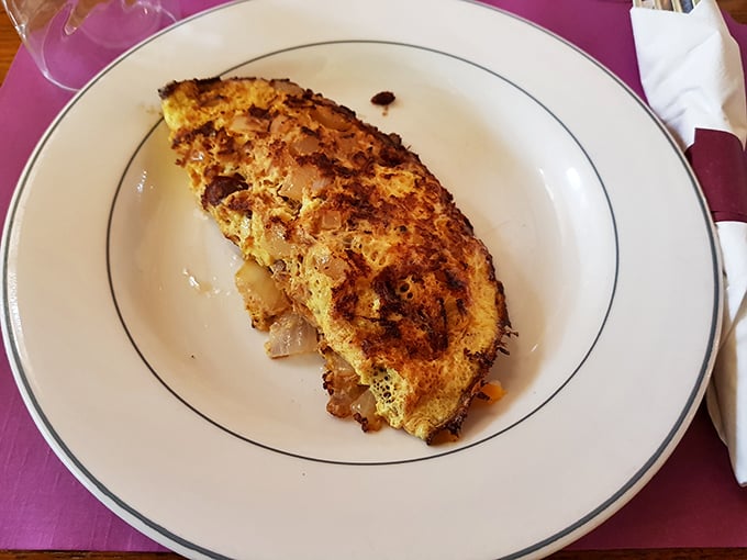 This isn't just an omelet—it's a masterclass in the art of breakfast engineering, with perfectly browned edges holding a treasure of savory fillings.