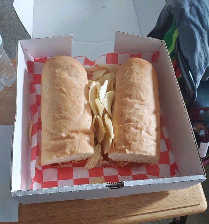 Behold the humble yet mighty pizza sub in its natural habitat—a checkered paper-lined box that barely contains its delicious potential.