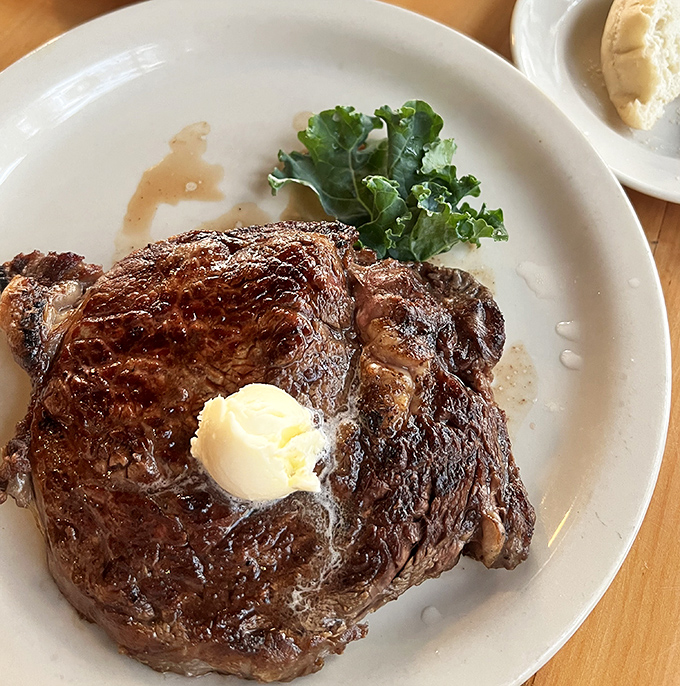 A perfectly seared ribeye with a pat of melting butter—proof that sometimes the simplest pleasures are the most profound.