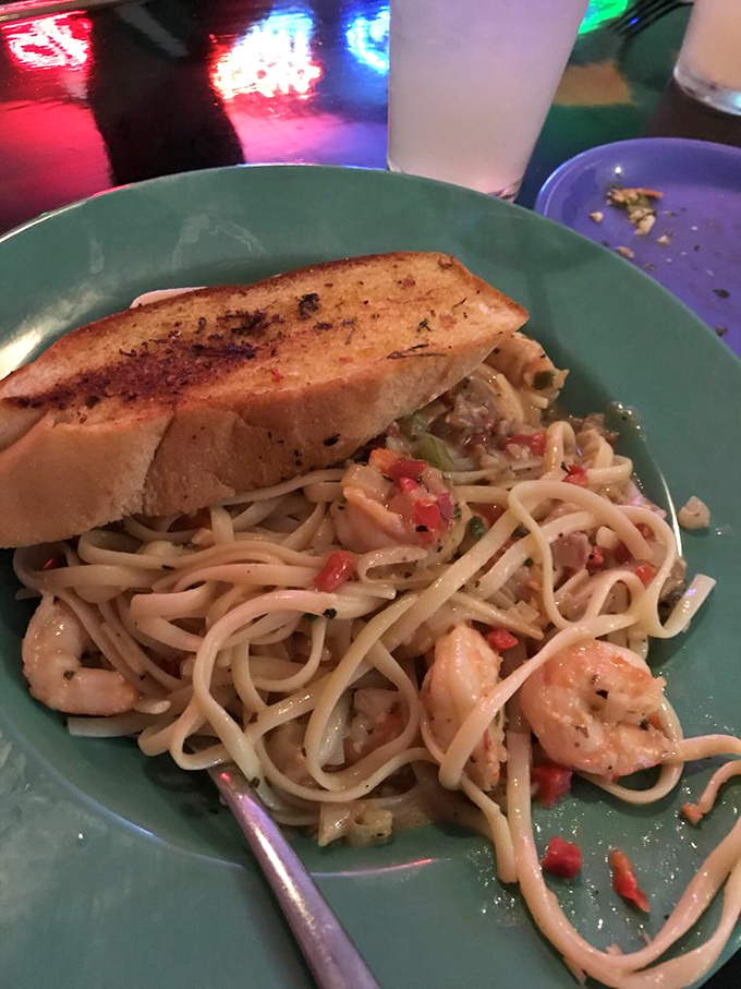 Shrimp scampi that demands your attention—plump crustaceans lounging in pasta like they're on vacation, with garlic bread standing by for essential sauce-sopping duties.