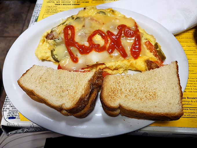 Breakfast artistry at its finest—an omelet personalized with the restaurant's name in ketchup. When your food knows who's serving it, you're in the right place.