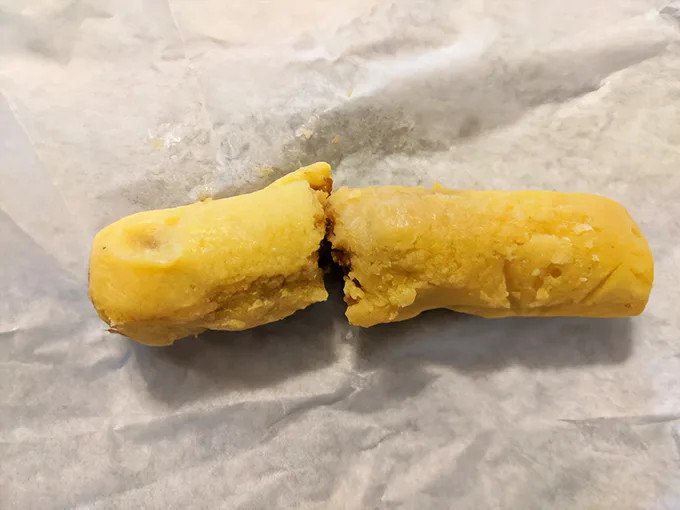 The mysterious corn roll tamale in its natural habitat—simple, unassuming, and hiding more flavor than its humble appearance suggests.