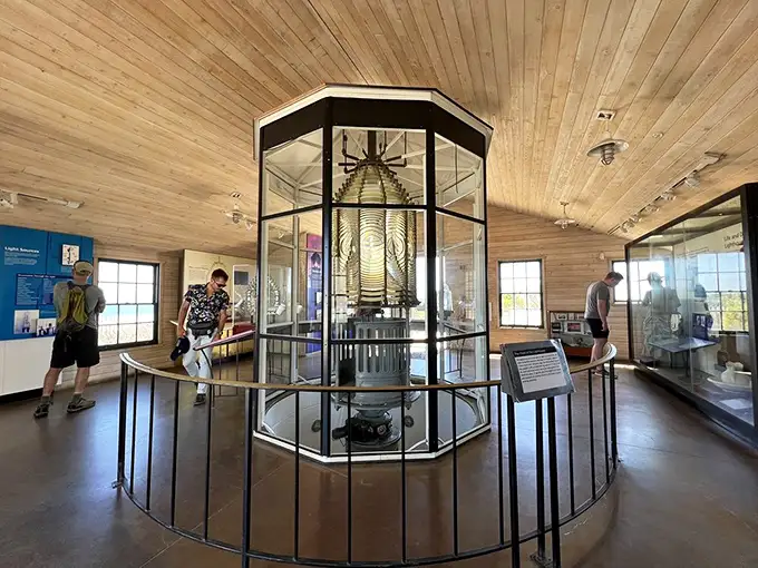 Modern visitors admire the historic Fresnel lens display. Before GPS, this ingenious glass beehive was the difference between safe harbor and disaster.