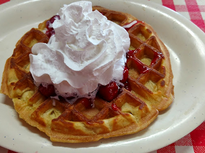 Behold the waffle that launched a thousand road trips – golden perfection topped with whipped cream dreams.