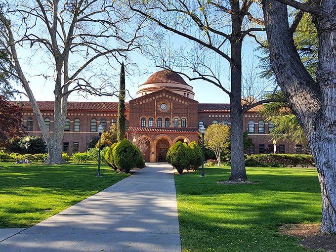 Chico State's historic Kendall Hall stands proudly among towering trees, offering affordable cultural events for seniors living on a budget.