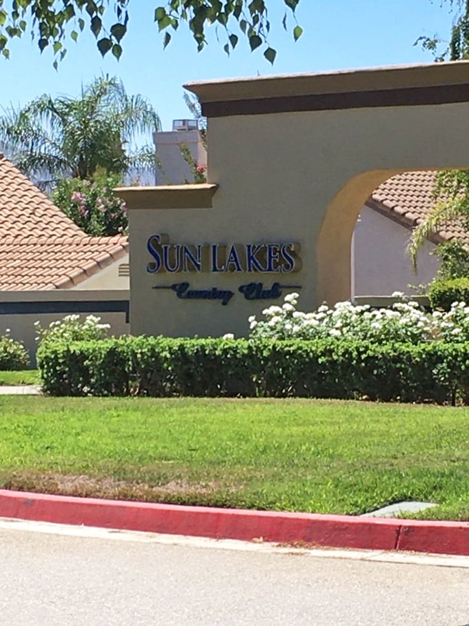 The entrance to Sun Lakes Country Club—where the sign says "exclusive" but your bank account says "thank goodness."