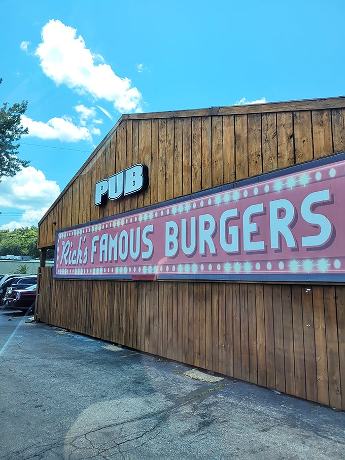 That pink neon sign glowing against weathered wood is like a treasure map—X marks the spot for burger gold.
