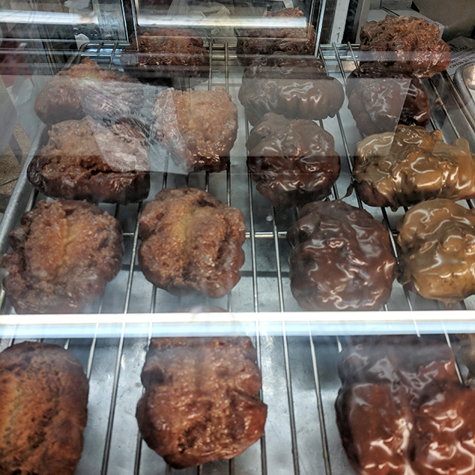 These apple fritters aren't just donuts—they're architectural marvels of caramelized crust and tender interior that could make a pastry chef weep.