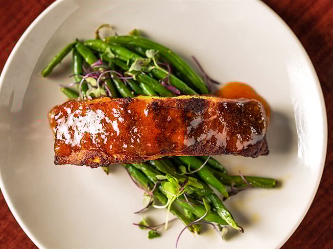 Salmon that's dressed better than most people at a wedding. The sweet-savory glaze creates a perfect harmony with those vibrant green beans.