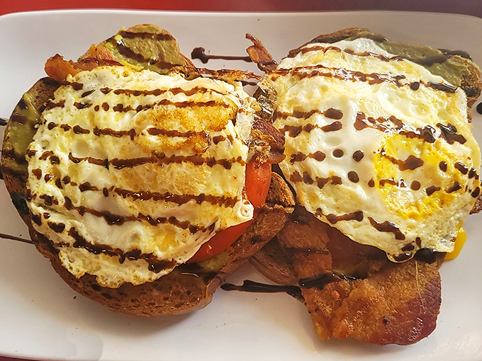 Eggs on toast? No, this is breakfast architecture—perfectly cooked eggs atop a foundation of goodness with that chocolate drizzle adding unexpected drama.