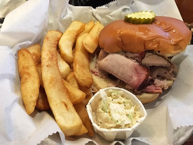 The sandwich that launched a thousand road trips. Golden fries, creamy slaw, and a bun struggling heroically to contain all that smoky pork goodness.