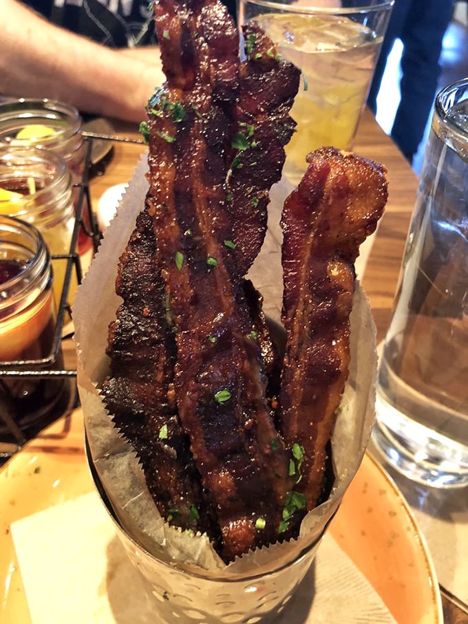 Bacon elevated to art form. These caramelized strips aren't just breakfast sidekicks—they're the main event, served with dipping sauces for good measure.