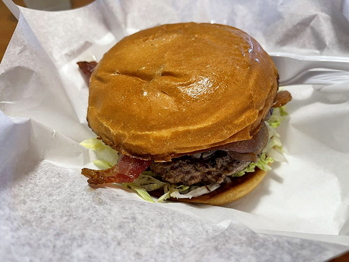 The bacon cheeseburger arrives like a beautiful meat monument—perfectly grilled patty, crisp bacon, and a bun that's somehow both sturdy and yielding.