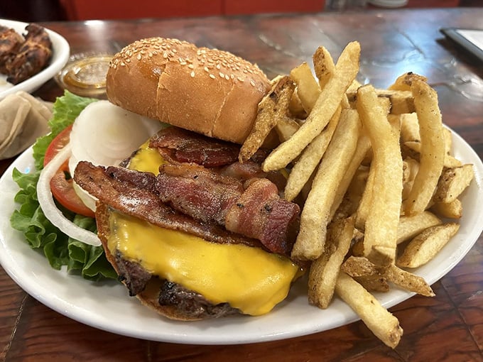 This isn't just a bacon cheeseburger; it's a masterclass in comfort food architecture—crispy bacon, melted cheese, and hand-cut fries that deserve their own fan club.