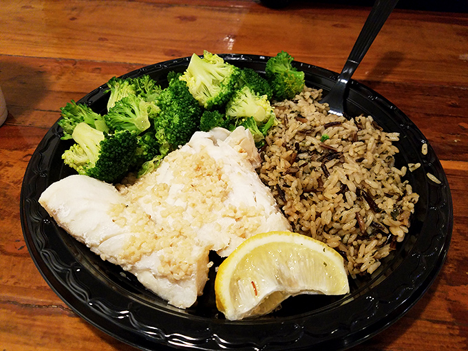The baked cod arrives like an old friend you didn't know you missed—flaky, tender, and paired with rice and broccoli for a guilt-free seafood affair.