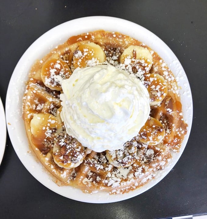 This banana-topped waffle with whipped cream isn't just breakfast – it's what dessert dreams about becoming when it grows up.
