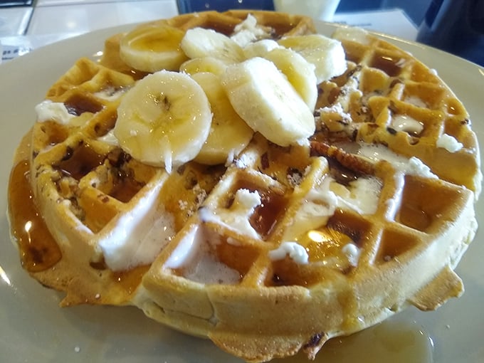 This Belgian waffle topped with banana slices isn't just breakfast—it's morning therapy. The syrup pools in those perfect squares like tiny lakes of happiness.