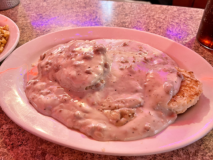 Comfort food incarnate—a tender biscuit completely smothered in rich, peppery sausage gravy. This isn't just breakfast; it's a warm hug for your taste buds.