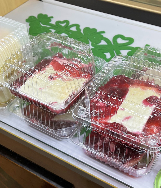 Dessert that doesn't need Instagram filters. These berry-topped treats wait patiently behind clear plastic, knowing their moment will come.